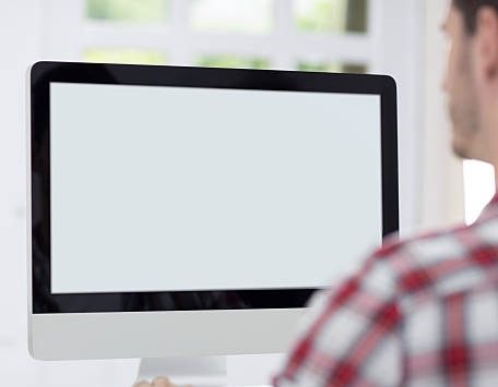 Man in front of computer screen – Training and Implementation Associates